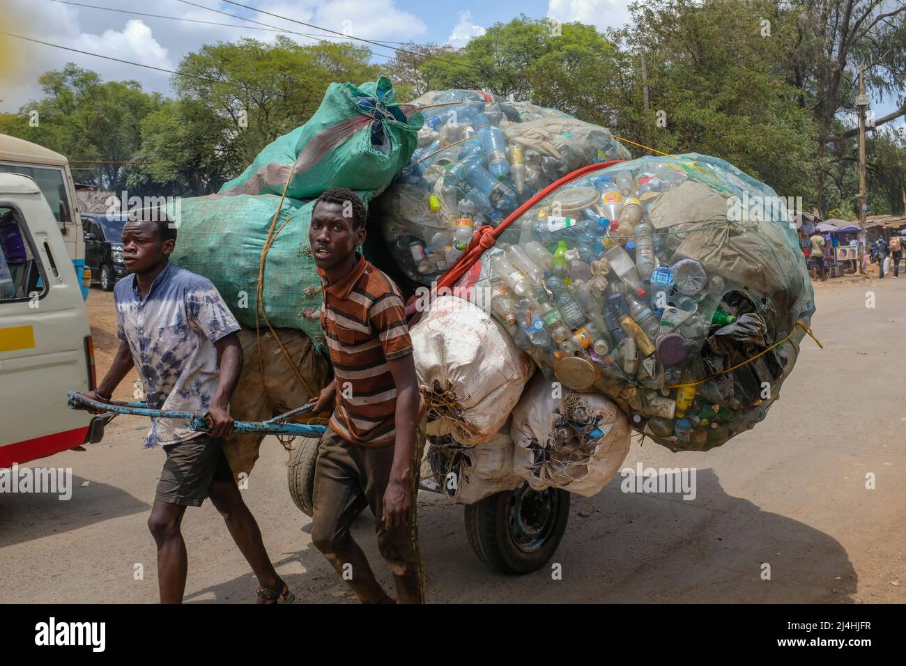 Nairobi, Kenya. 14th Apr, 2022. Young boys pull sacks of heavy plastic ...
