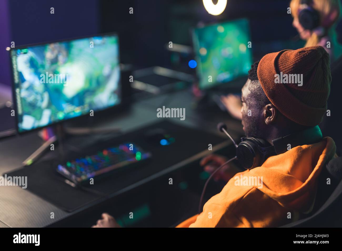 concentrated young gamer in headphones playing video game in computer ...