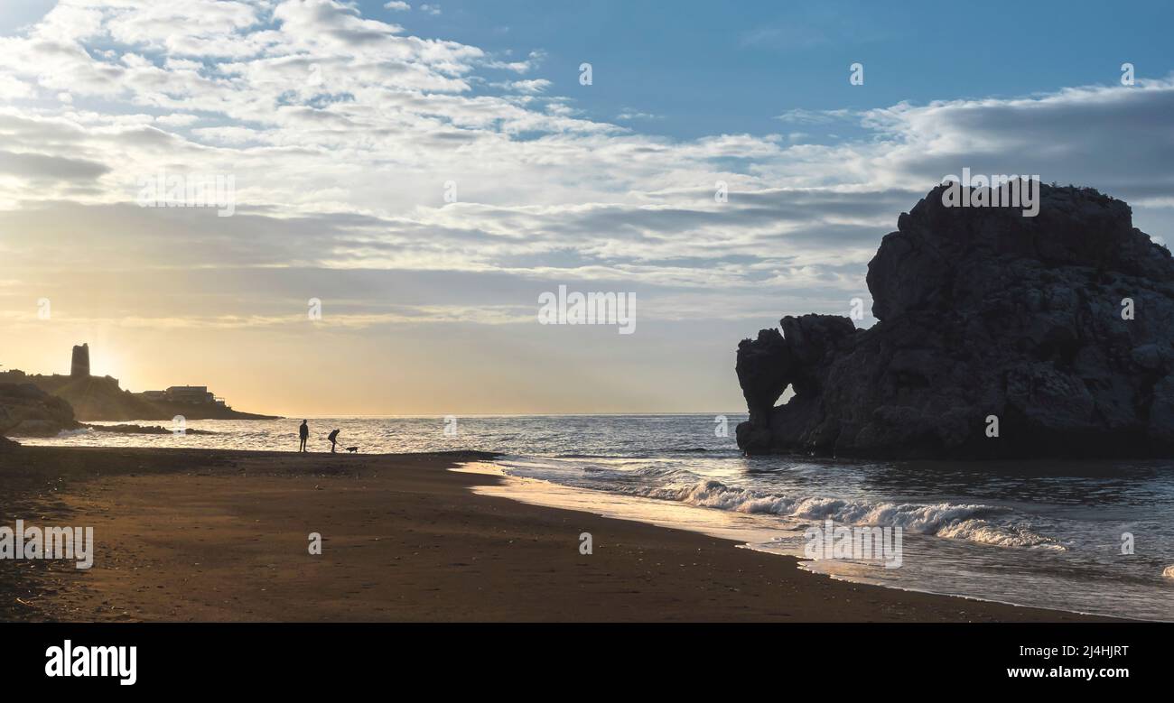 Landscape of a beautiful sunrise on a beach with two unrecognizable ...