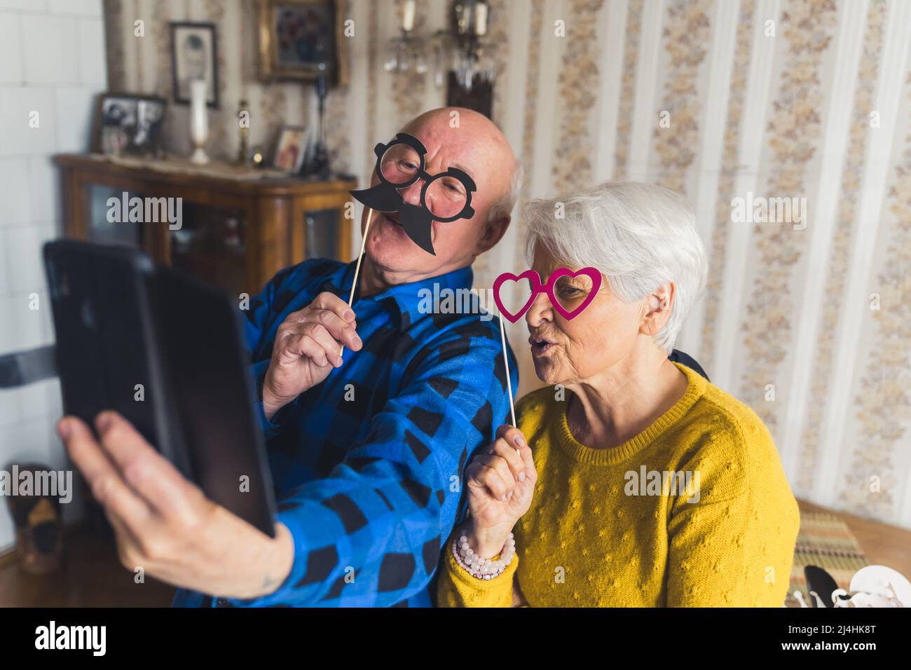 Playful and cheerful elderly couple takes a selfie in their vintage ...