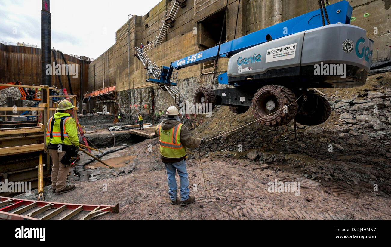 Contractors move a boom lift within the lock chamber for a project ...