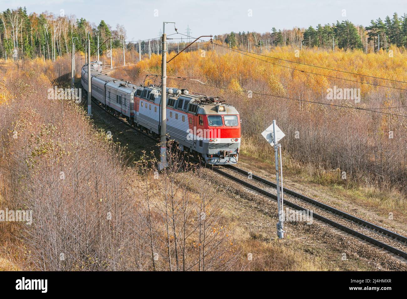 Passenger train moves at autumn morning time Stock Photo - Alamy
