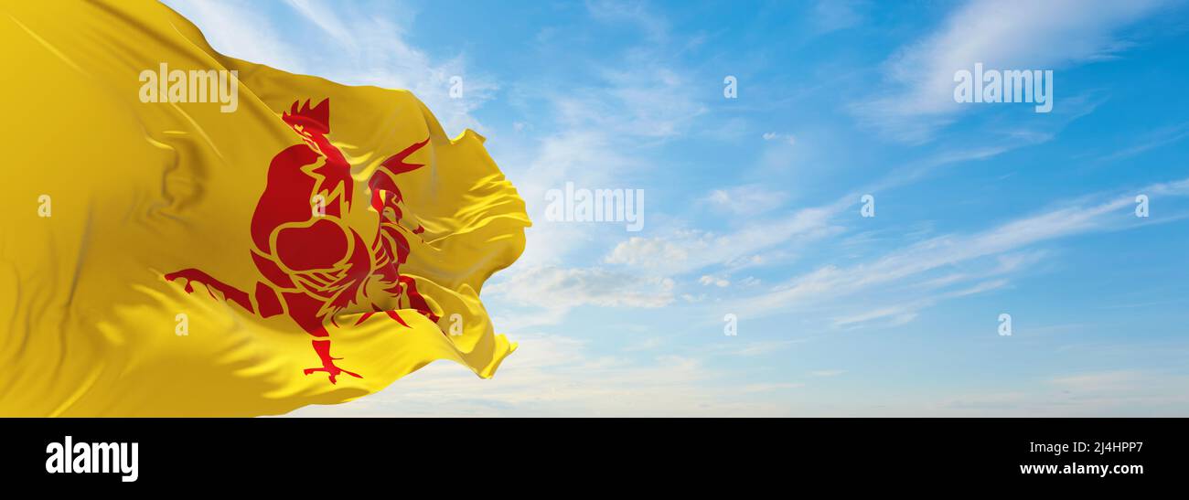 official flag of Wallonia, Belgium at cloudy sky background on sunset ...