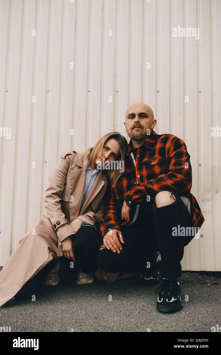 Loving couple stand near wall and look in camera hipster Stock Photo ...