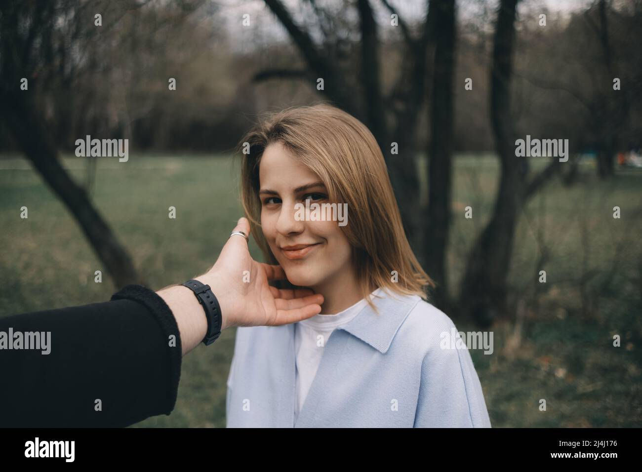 a man caresses the face of his beloved outside. She is smiling Stock ...