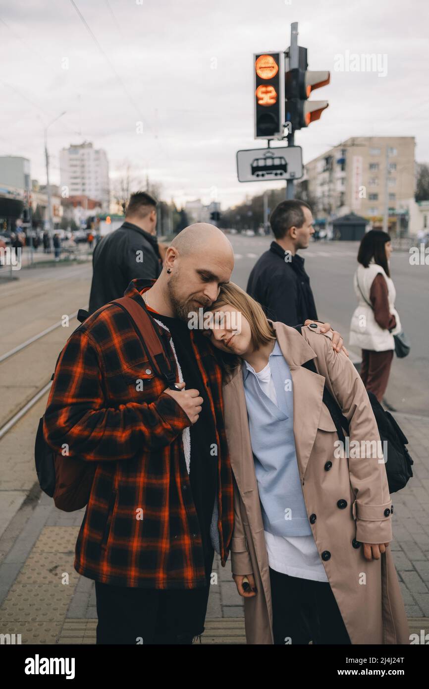 loving couple standing wearily in the arms of the city ith eyes clossed ...