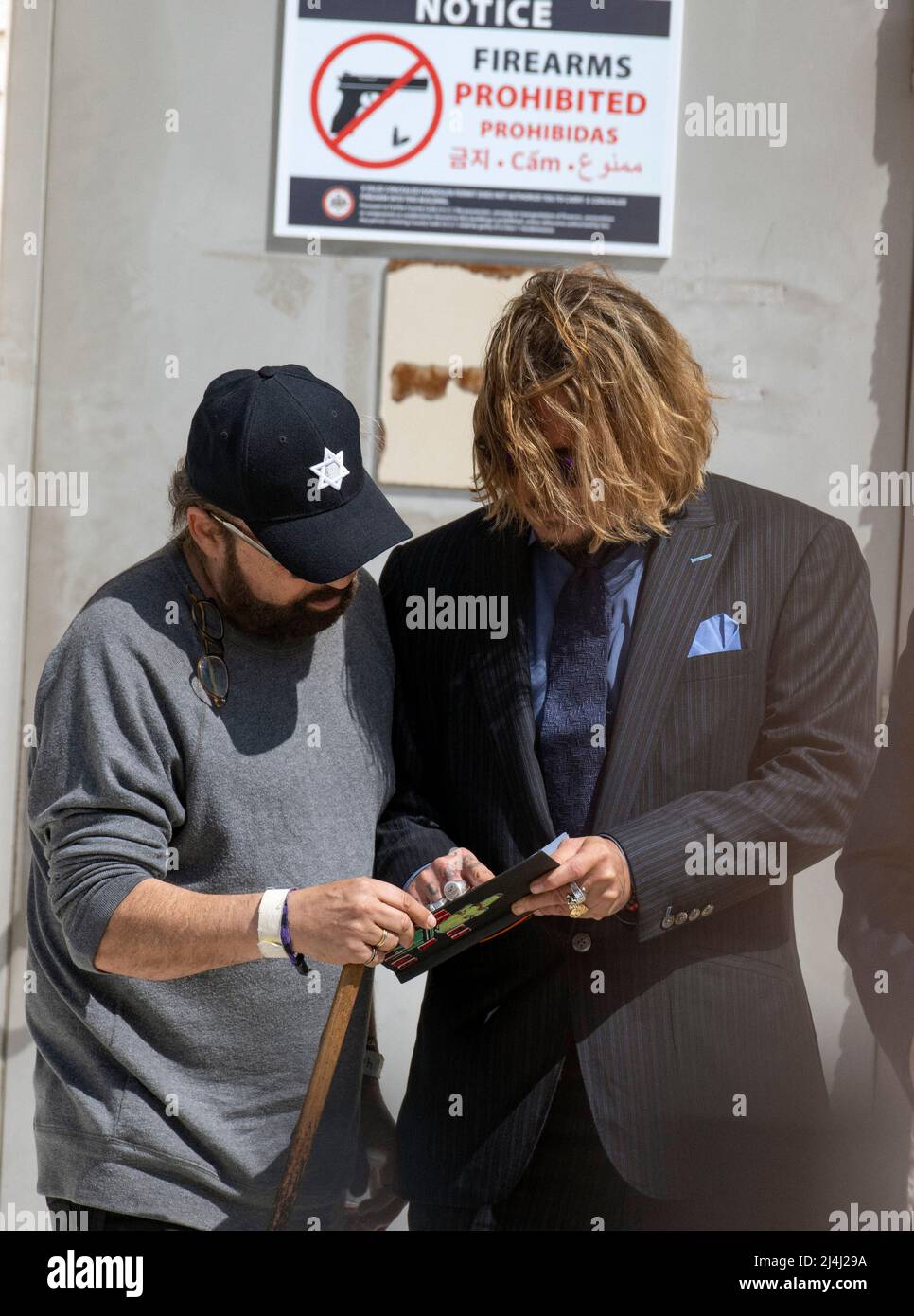 Johnny Depp reviews his notes with an unidentified member of his ...