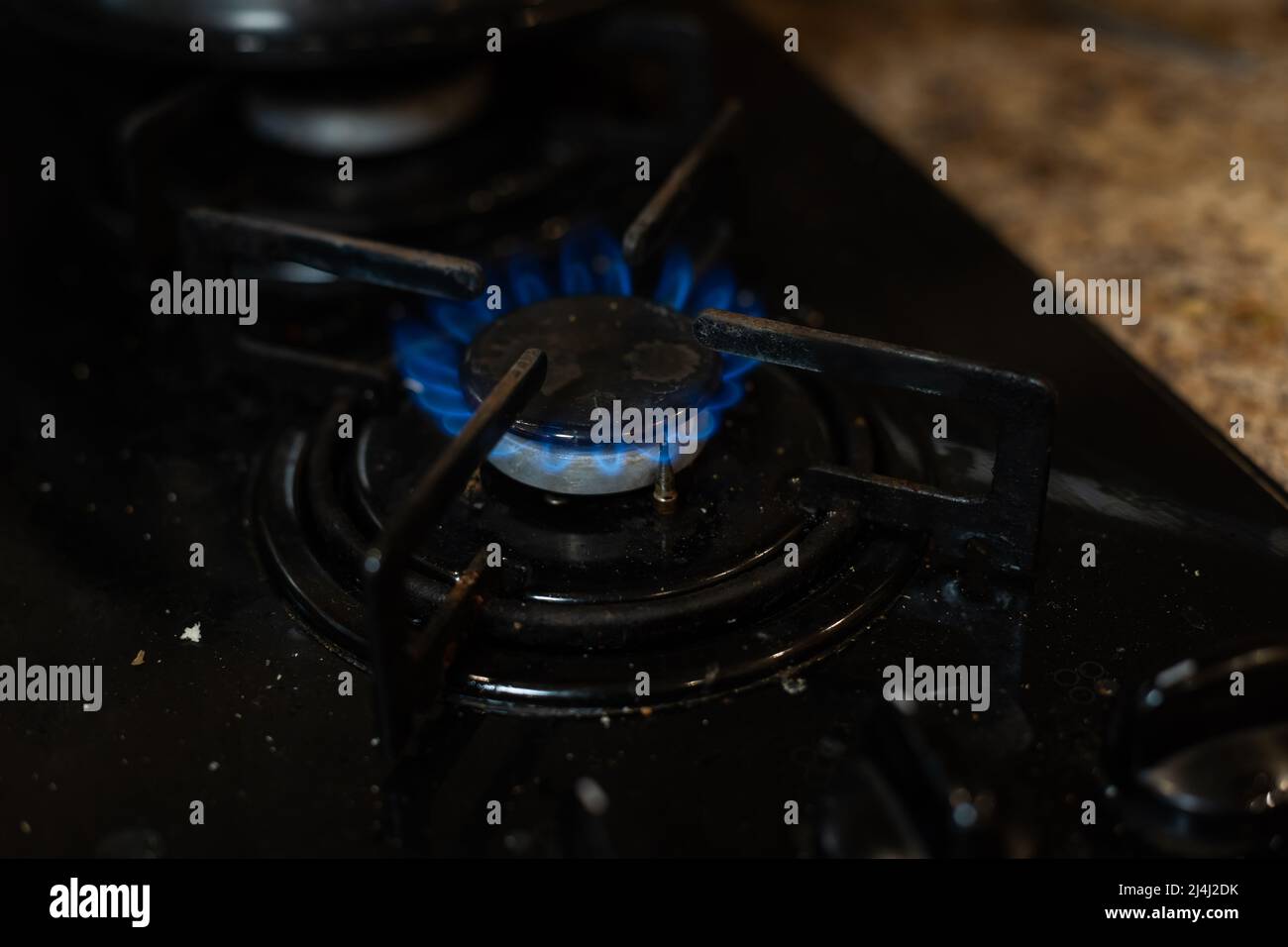 Closeup shot of blue fire from domestic kitchen stove top. Gas cooker ...