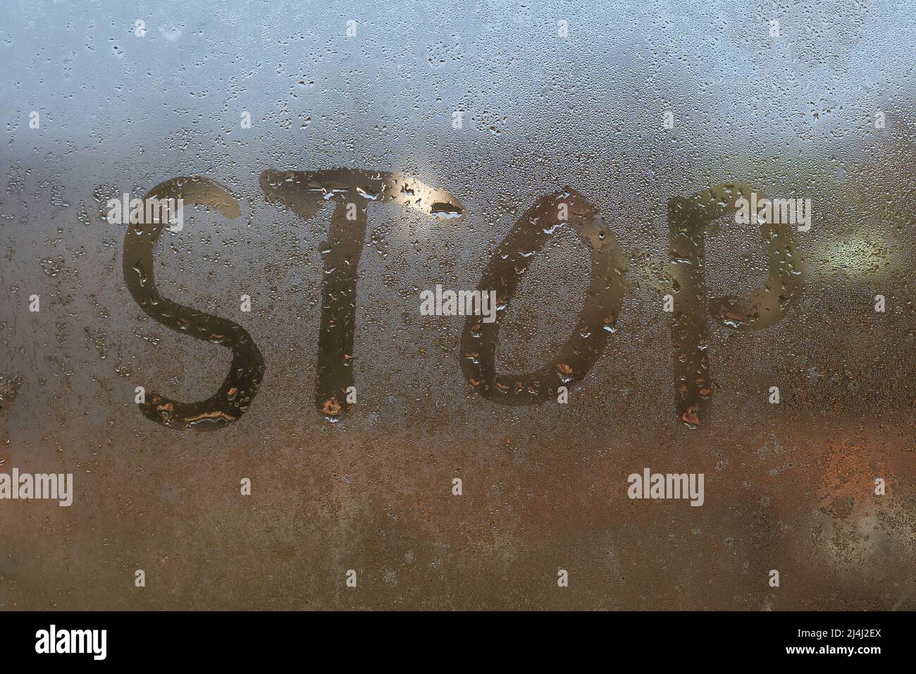 The Word Stop Written On Night Wet Window Glass Close Up With Blurred