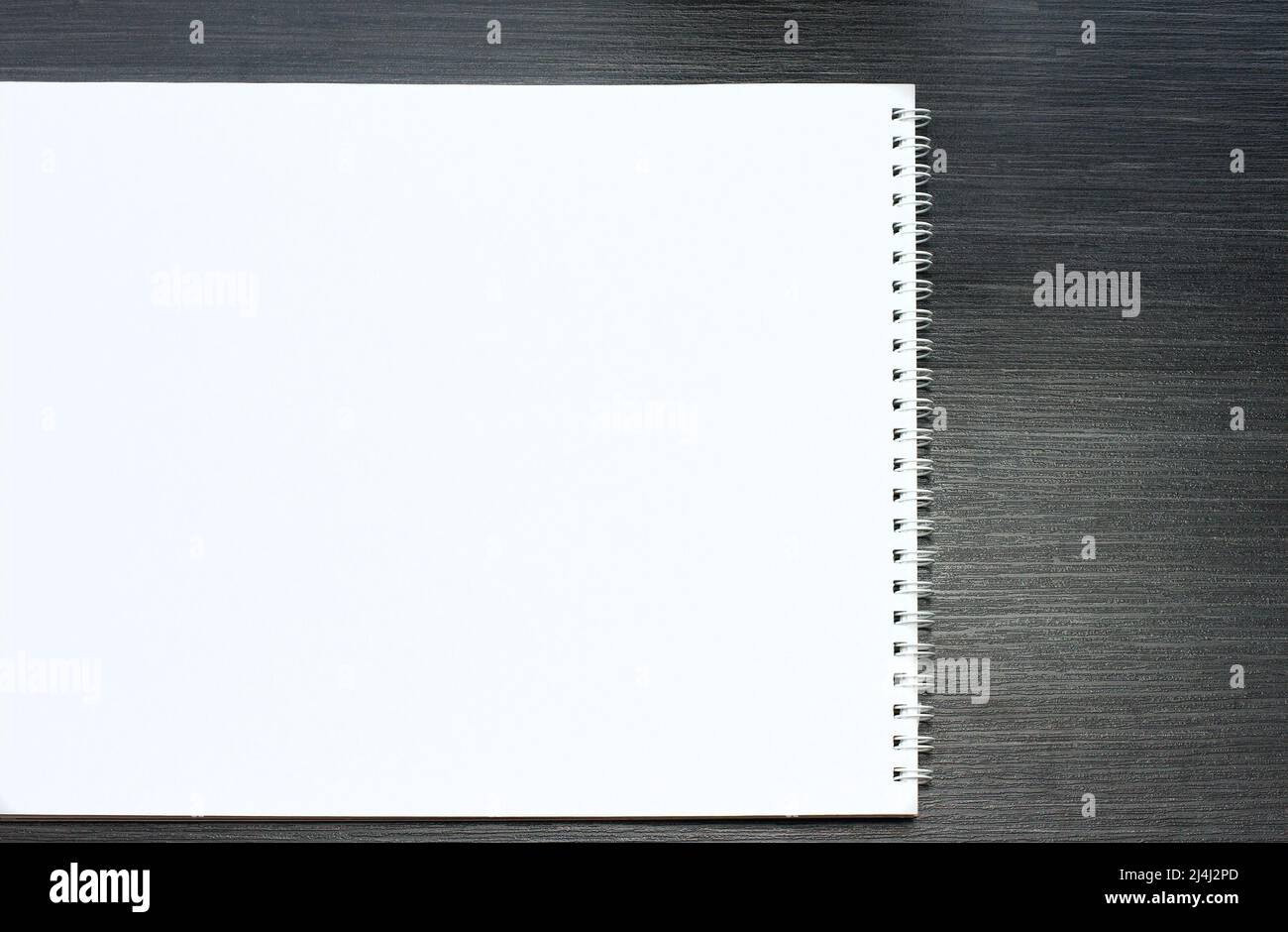 Blank notepad for sketching with white pages on black wooden table ...
