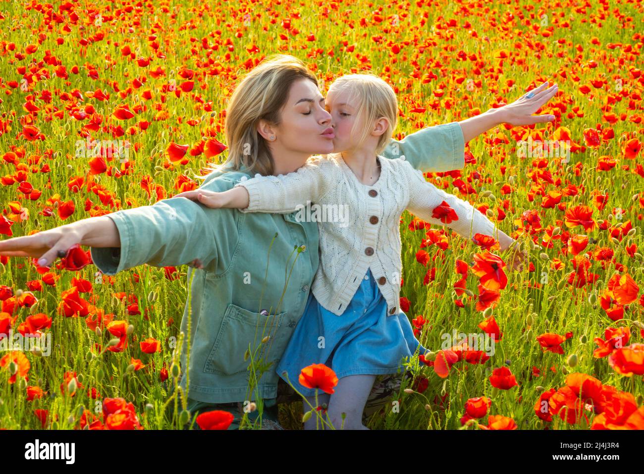 Happy spring family. Mother with daughter on the poppies meadow ...