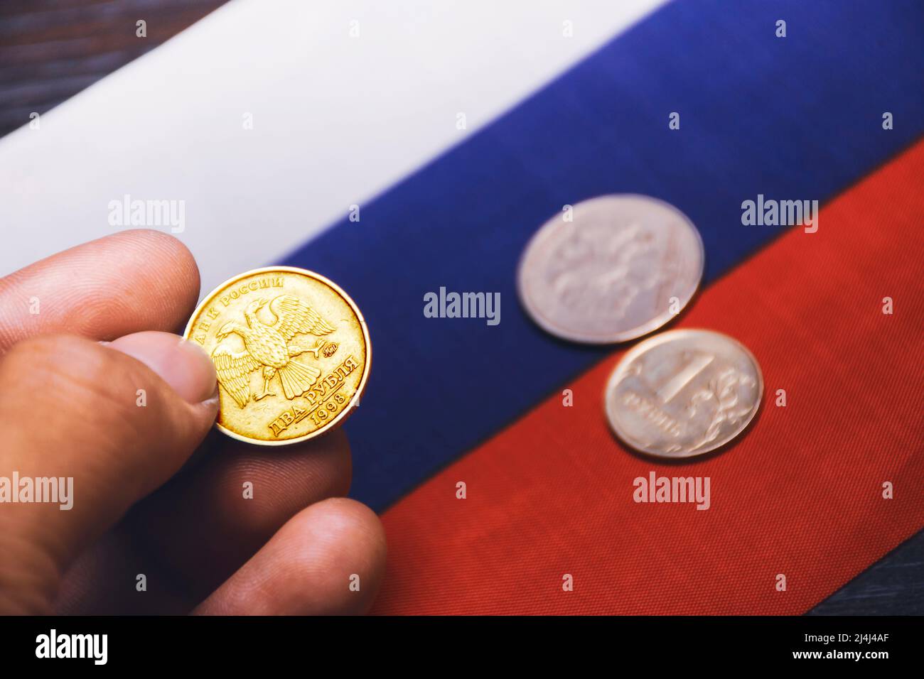 Gold ruble coin on the hand and the flag of Russia on background Stock ...