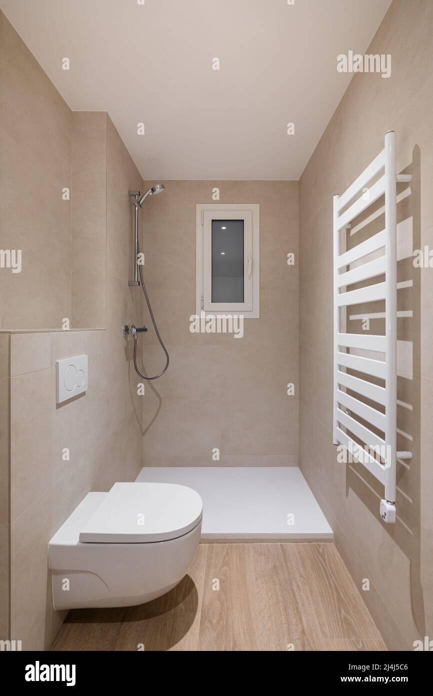 Bathroom with toilet, shower and heating radiator. Vertical view of ...