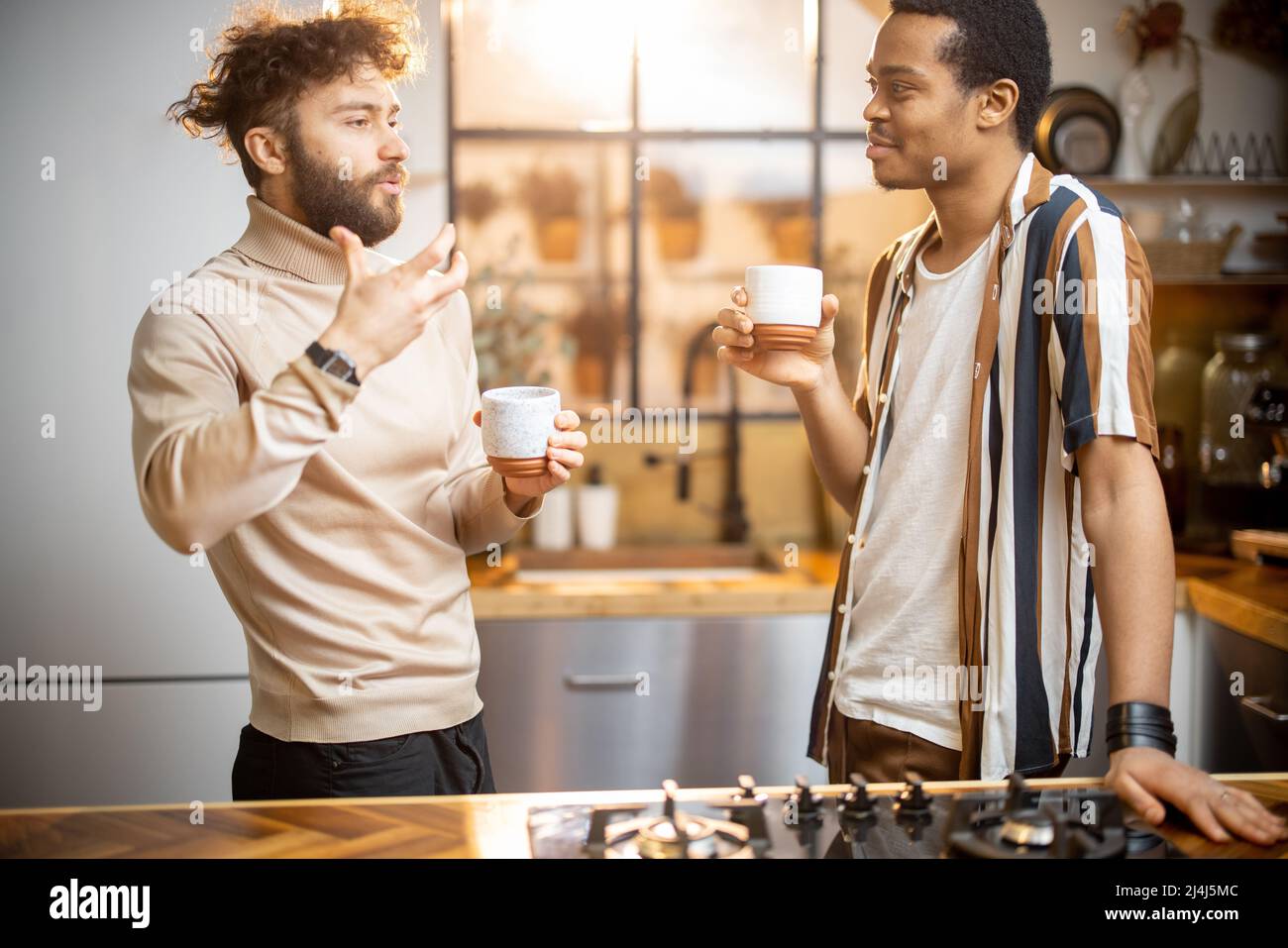 Two men talking and drinking coffee on kitchen at home Stock Photo - Alamy
