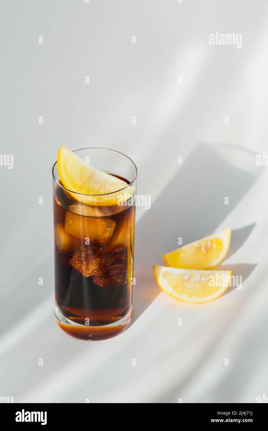 Glass of cola with ice and lemon Stock Photo - Alamy