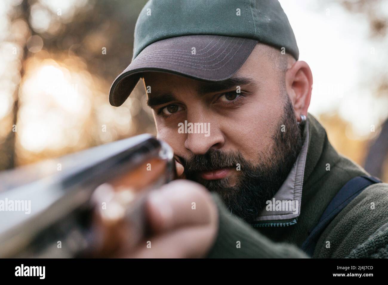Male hunter looking at the camera while aiming a gun at his prey Stock ... Male hunter looking at the camera while aiming a gun at his prey Stock ...