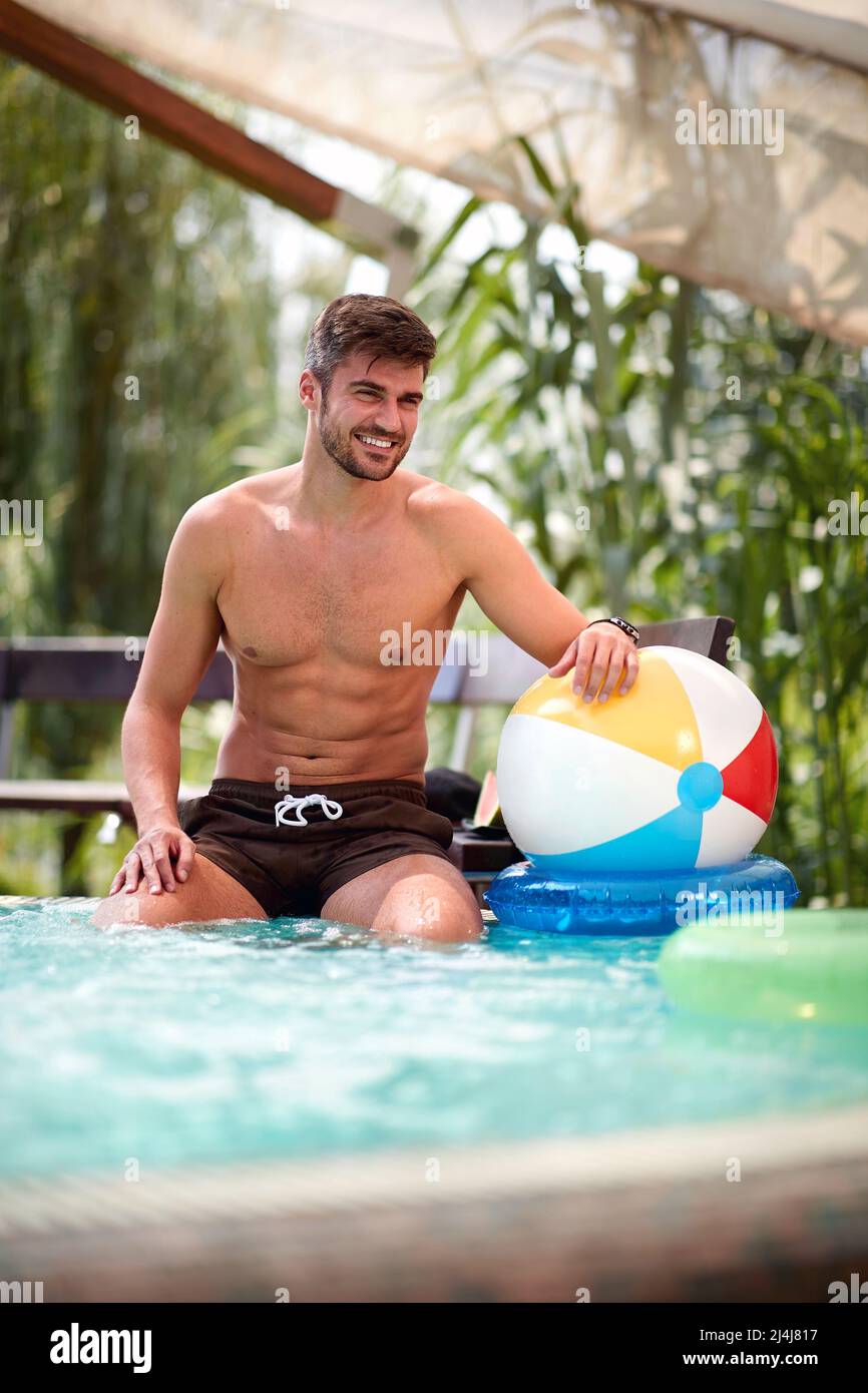 Handsome young man on swimming pool Stock Photo - Alamy