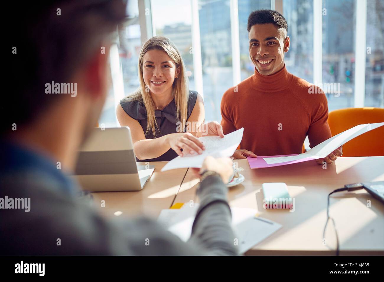 Close-up of young colleagues in a commission having a pleasant talk ...