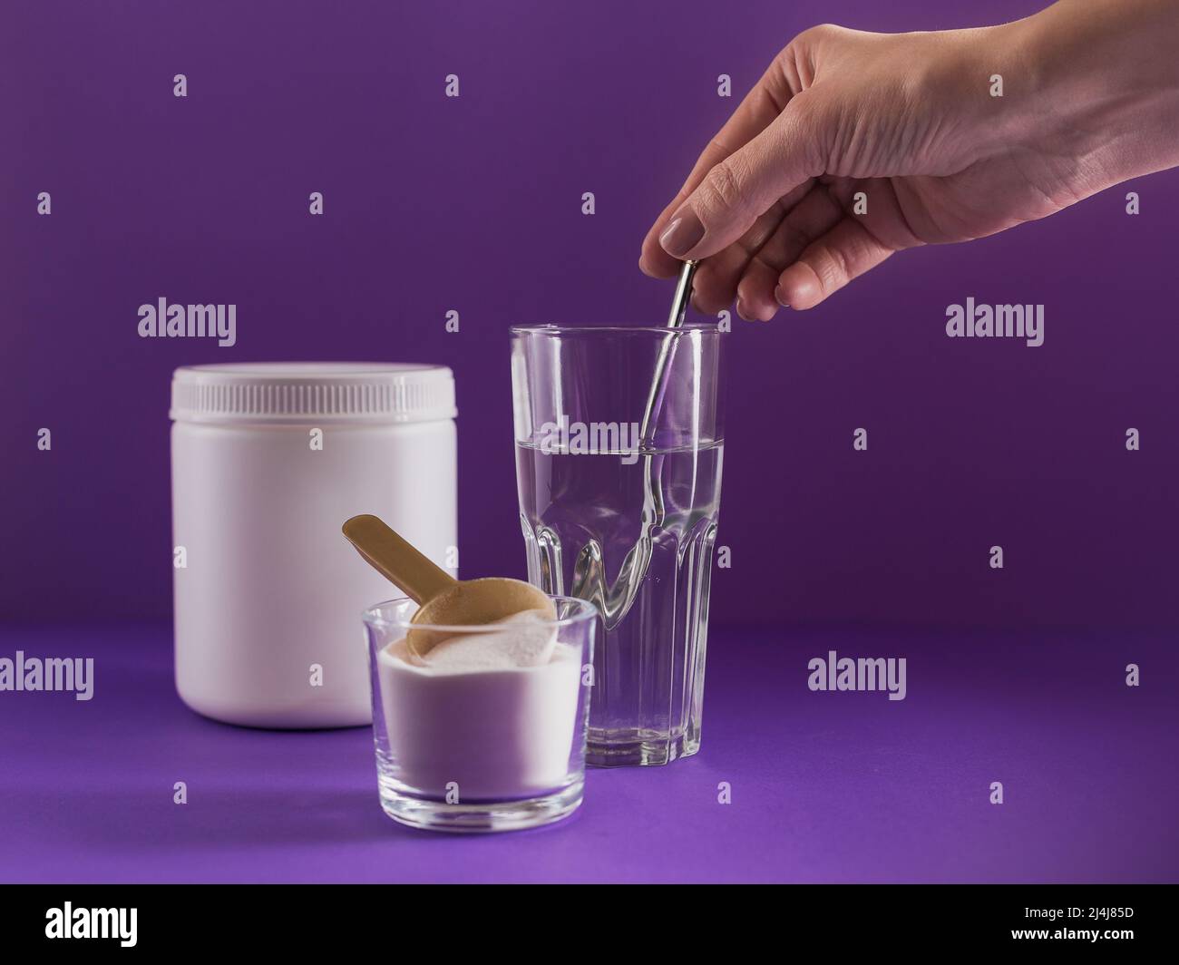 Glass with collagen dissolved in water and collagen protein powder on ...