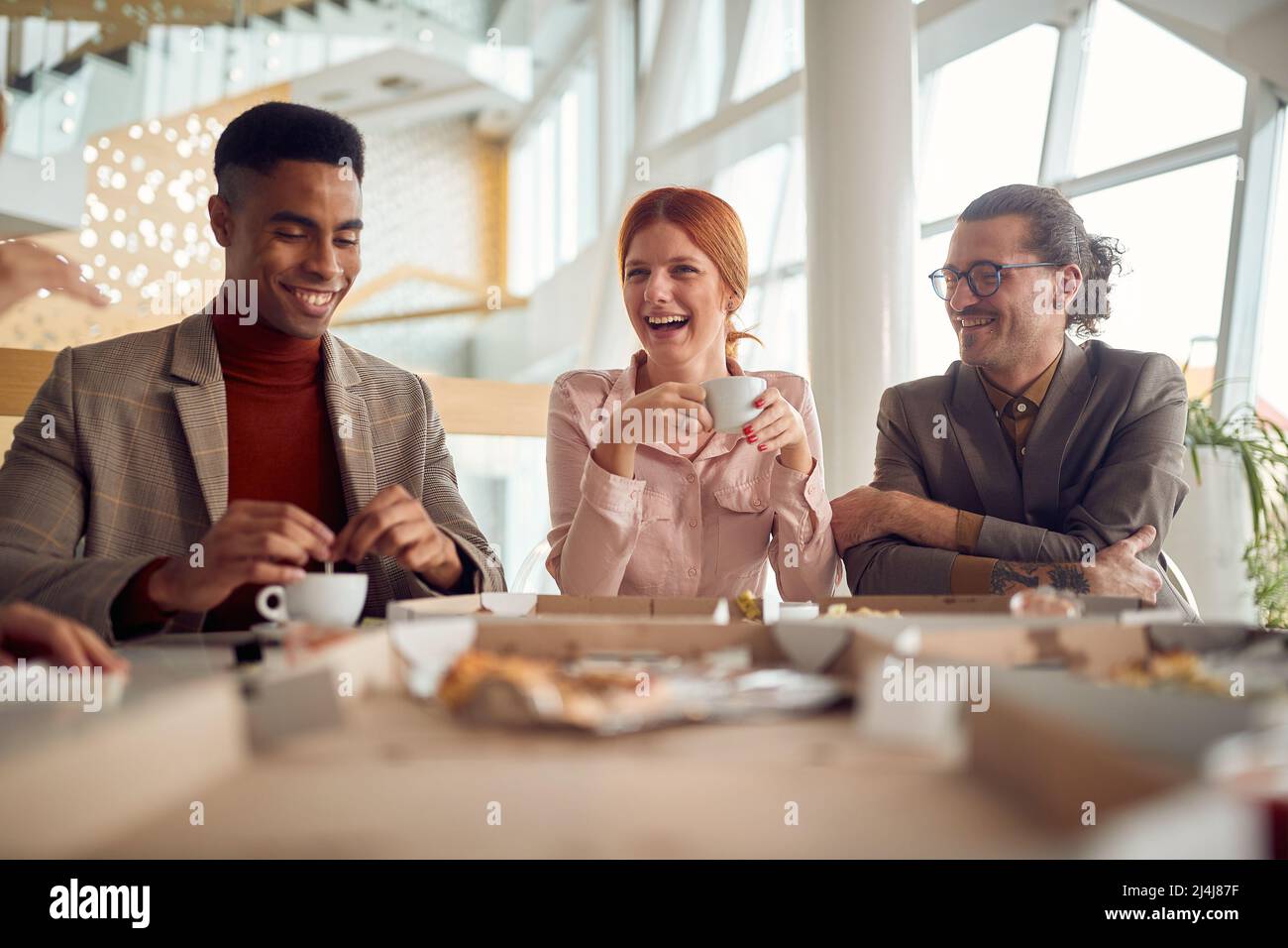 A young cheerful business woman and her male colleagues are in a very ...