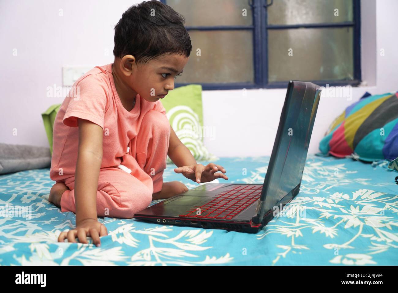 a toddler baby boy engaged in watching and exploring laptop.Screen time ...