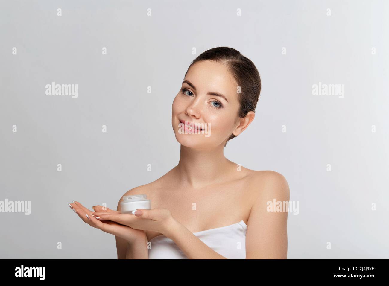 Beautiful Woman with healthy smooth facial clean skin holding bottle ...