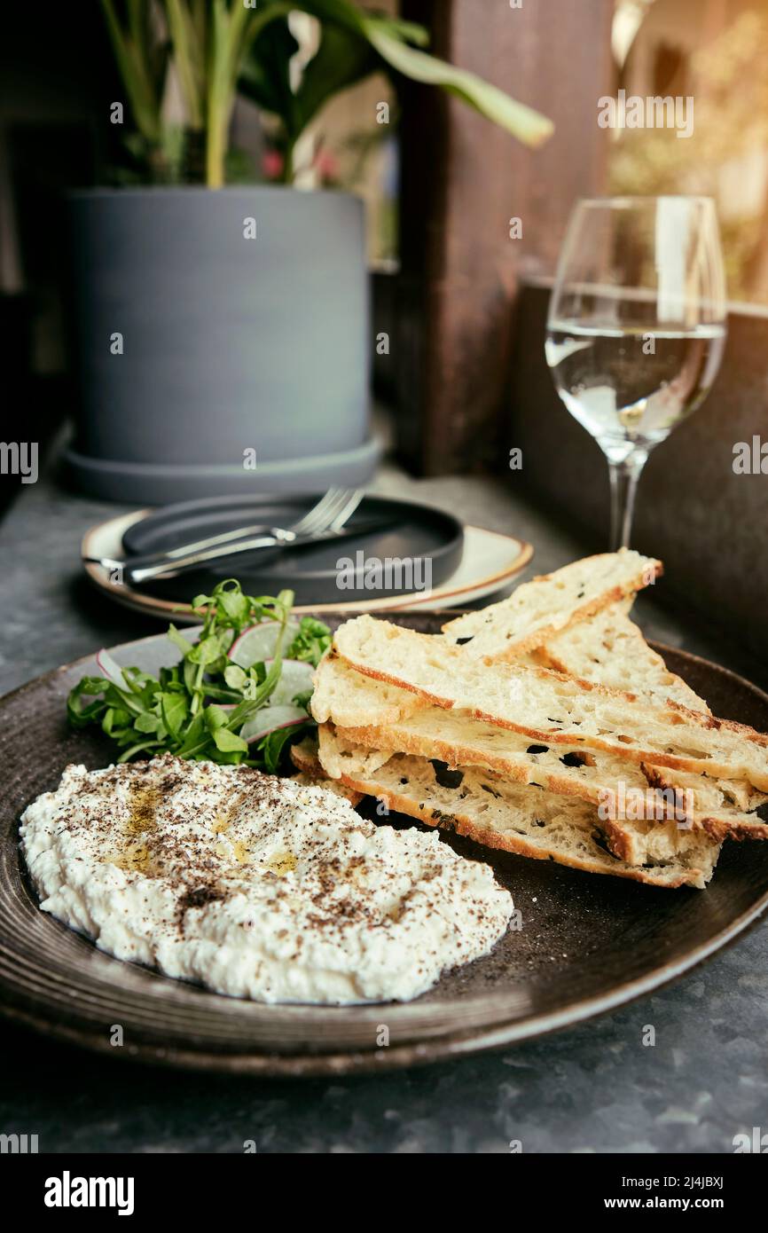 Italian cheese stracciatella -buffalo mozzarella- on a black plate ...