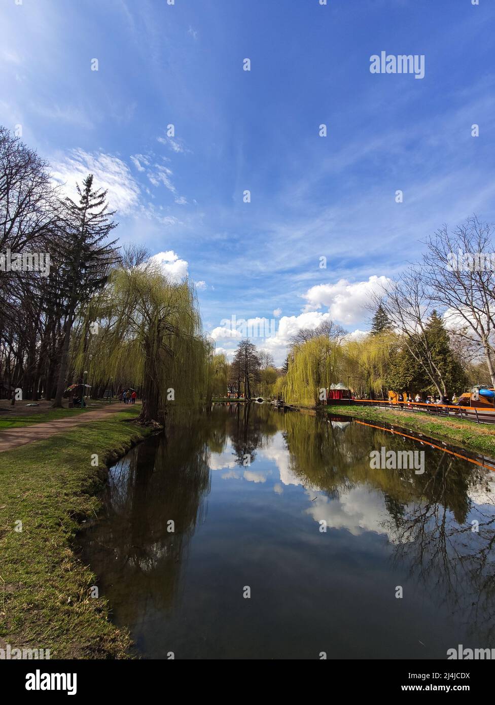 a beautiful river in the park with sky reflection and trees in spring ...