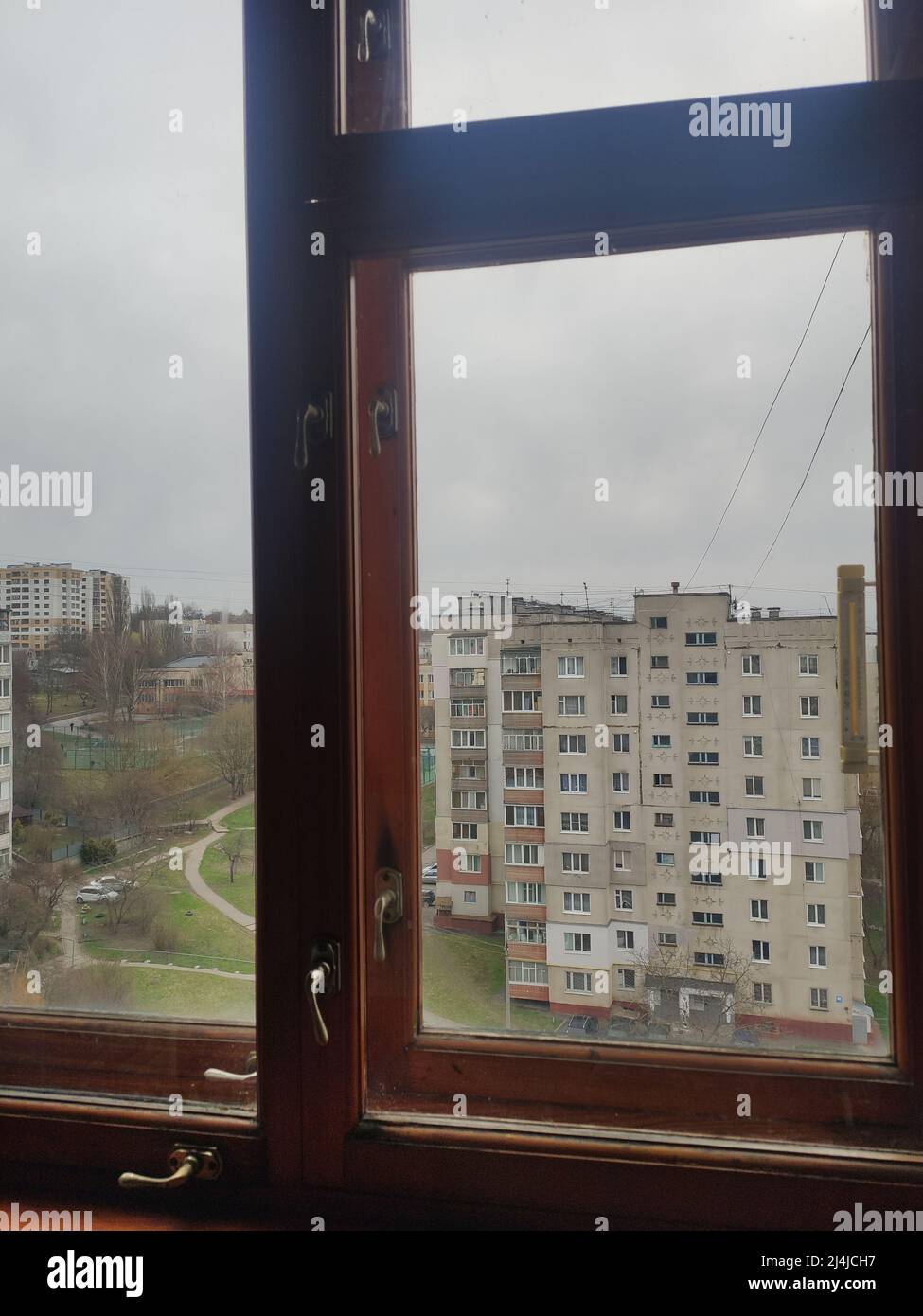 a view from the wooden window to the high apartment buildings of the ...