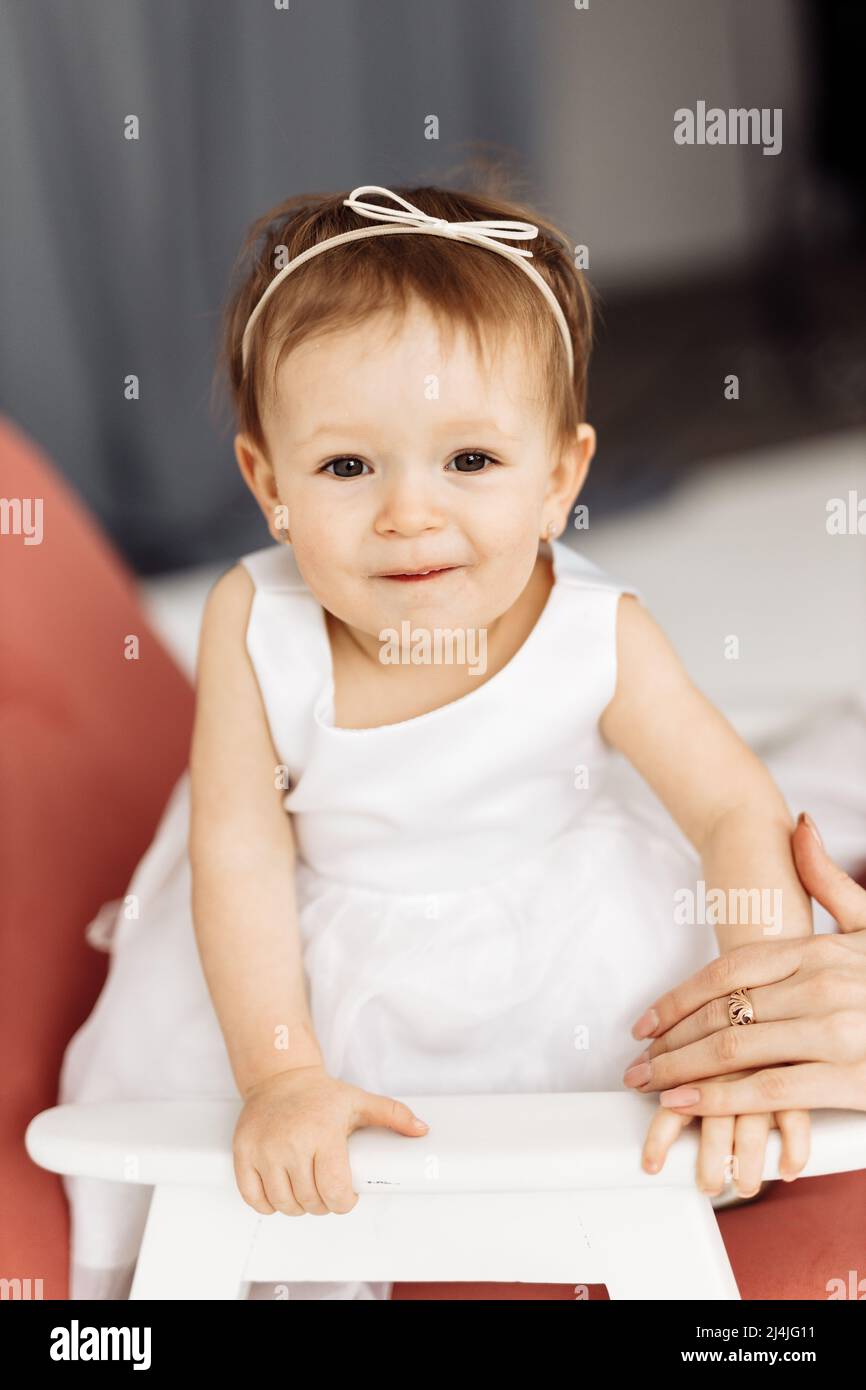 Little blonde positive princess girl in white casual dress and shoes ...