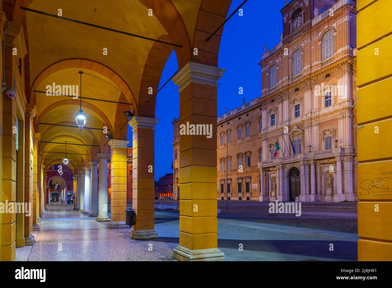 Sunrise view of Palazzo Ducale through an arcade in Italian town Modena ...