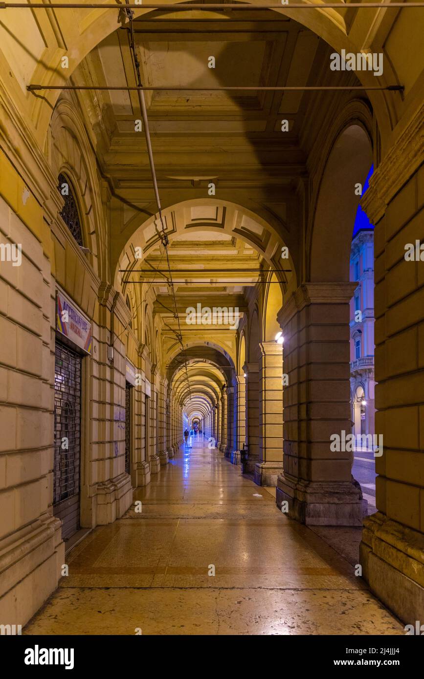 Night view of a covered arcade in the historical center of the italian ...