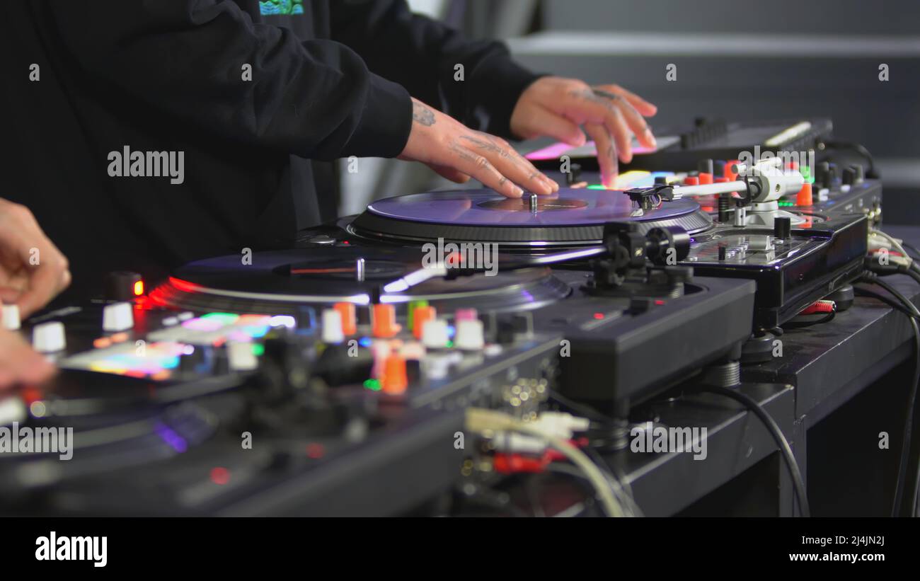 DJ spinning record at disco. Art. Close-up of DJ's hand on mixer ...