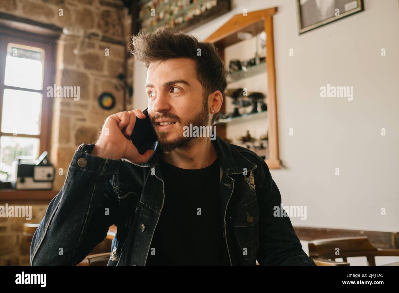 Phone call, young handsome man talking on the phone in an old cafe ...