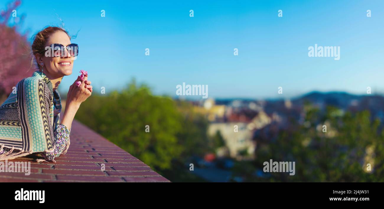 Happy young carefree woman enjoying spring panorama with toothy smile ...