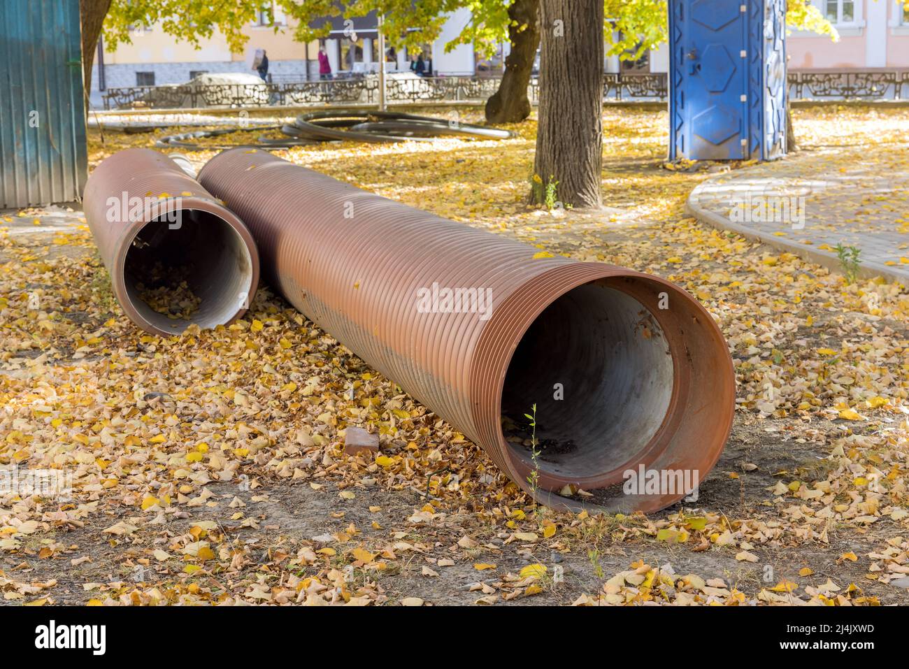 Drainage works in brown corrugated pipes awaiting laying during street ...