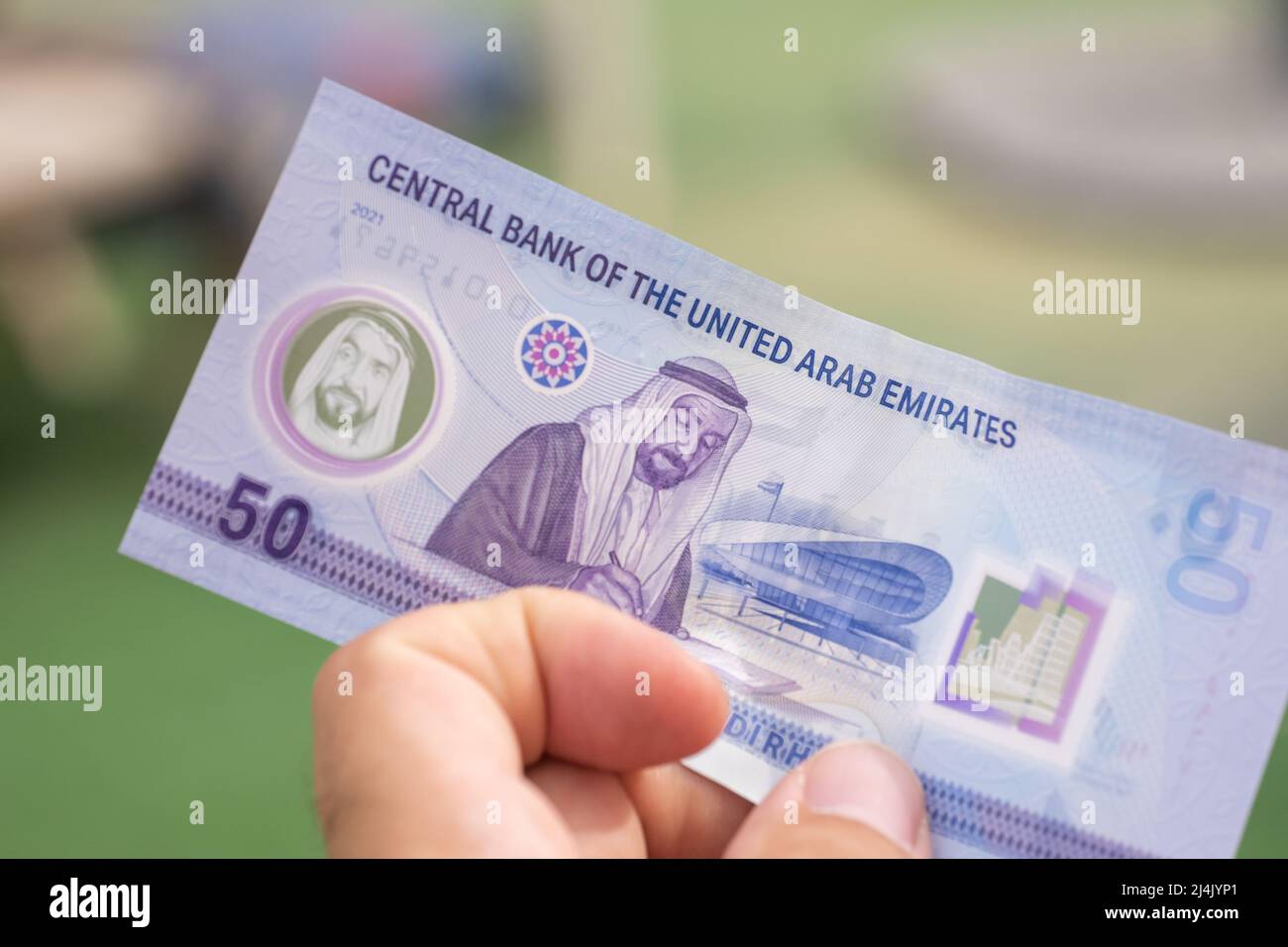 Persons hand giving the Currency of the United Arab Emirates (UAE ...
