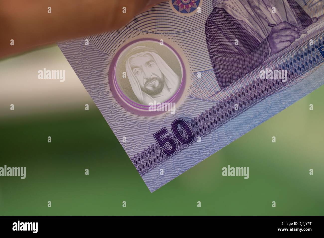 Persons hand giving the Currency of the United Arab Emirates (UAE ...