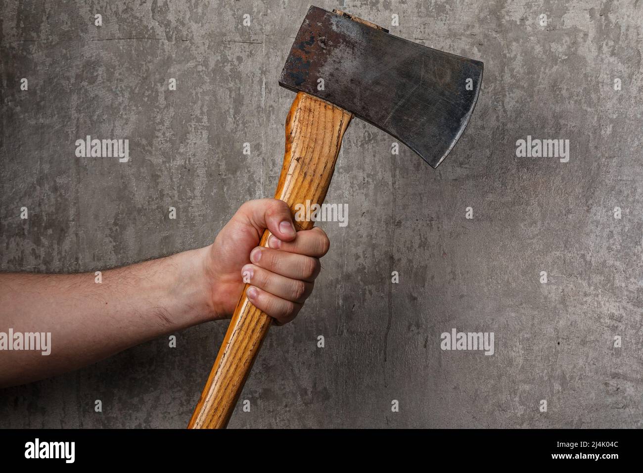Male hand holding axe over gray background Stock Photo - Alamy