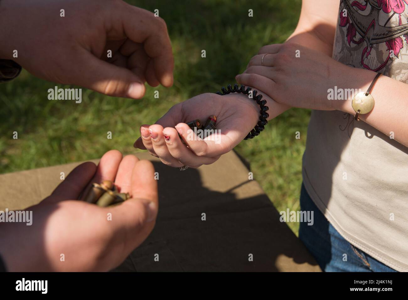 holding bullets for a rifle or pistol in a woman hand before shooting ...