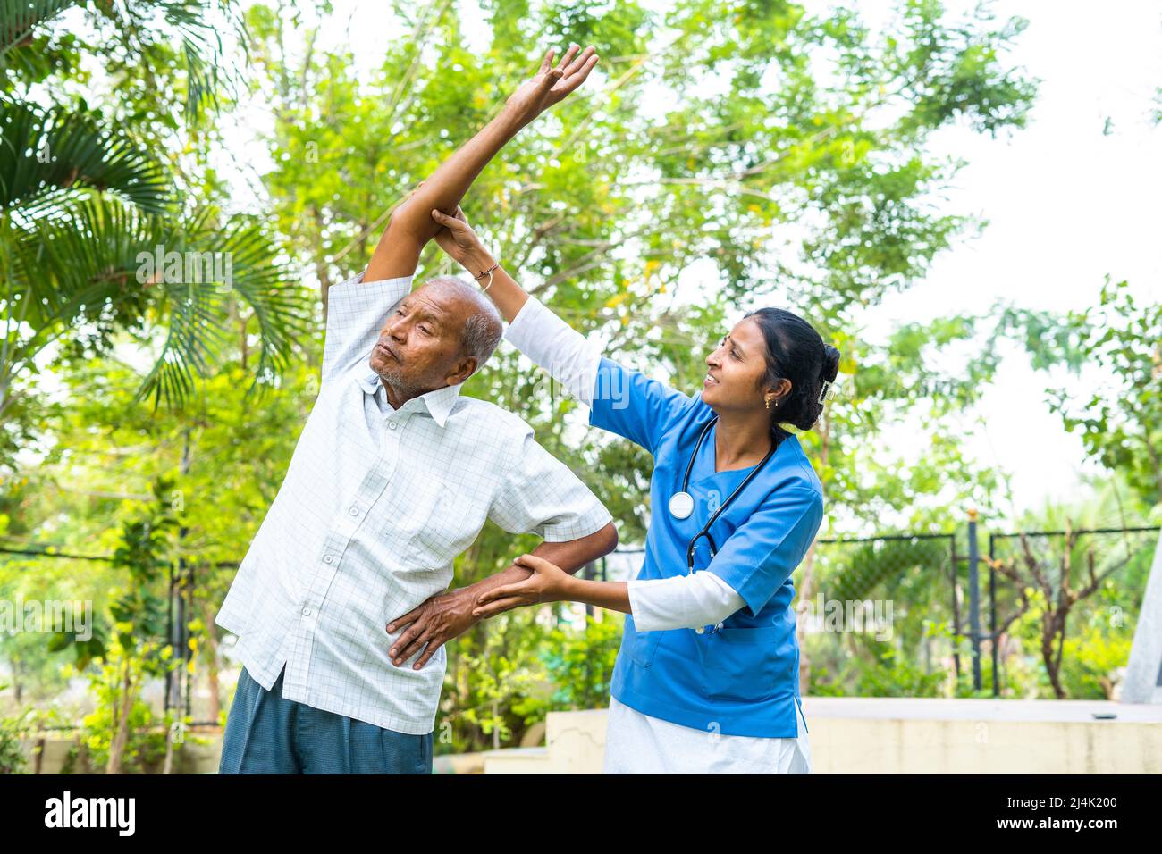 Nurse helping senior old man helping to do exercise at nursing home ...