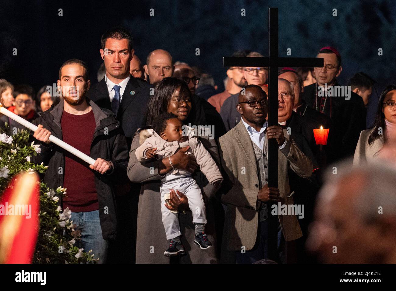 Rome, Italy. 15th Apr, 2022. A migrant family hold the cross as they ...