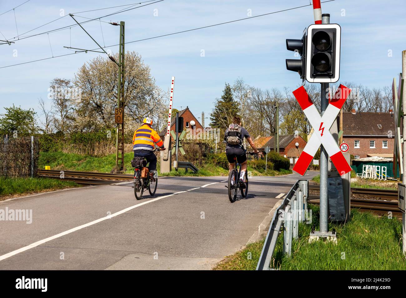 Cyclists cross a level crossing Stock Photo - Alamy