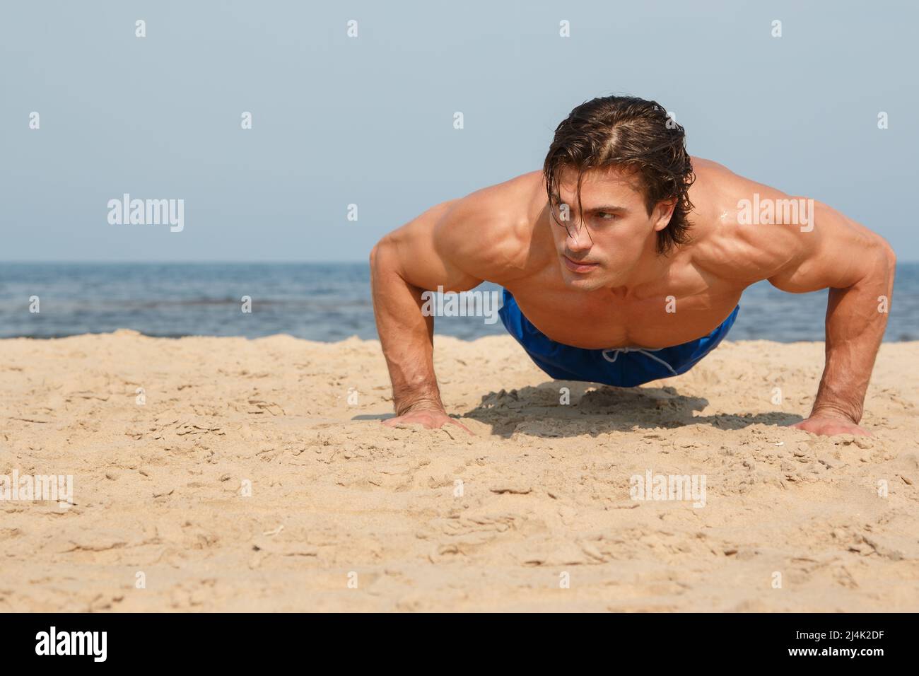 Muscular man during workout on the beach Stock Photo - Alamy