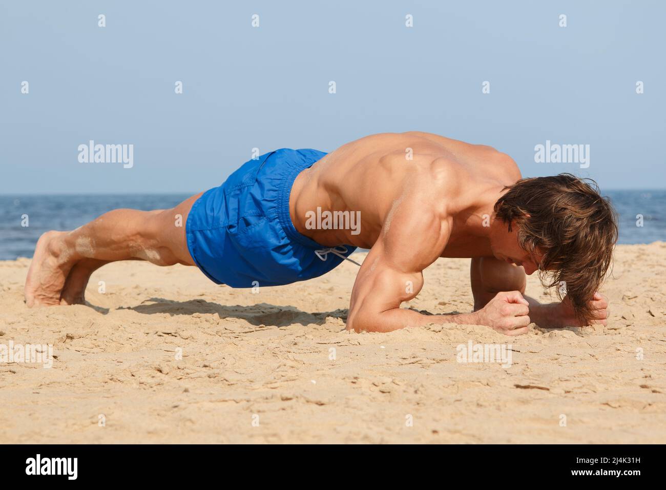 Muscular man during workout on the beach Stock Photo - Alamy
