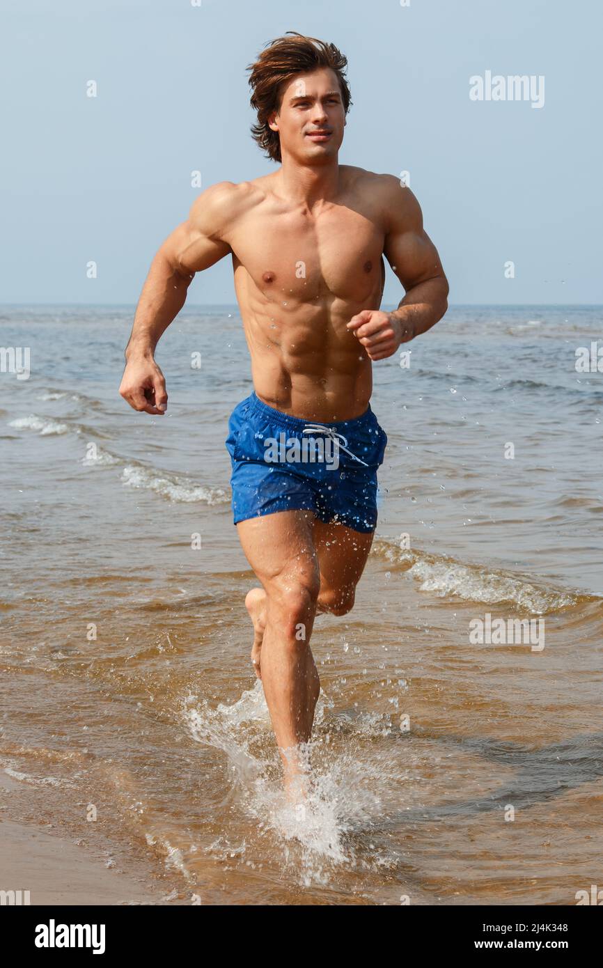 Muscular man during jogging by the sea coast Stock Photo - Alamy