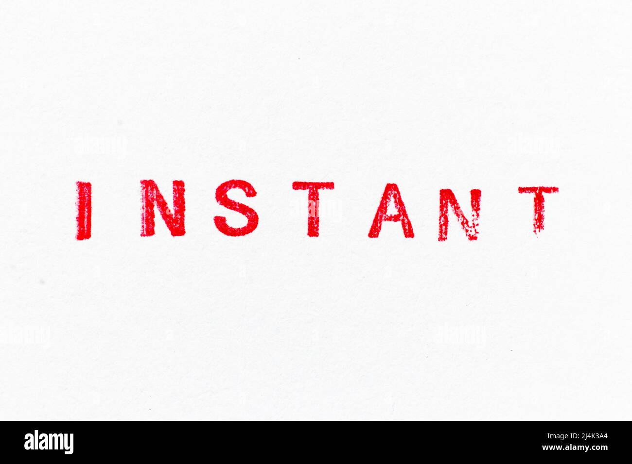Red color ink rubber stamp in word instant on white paper background ...