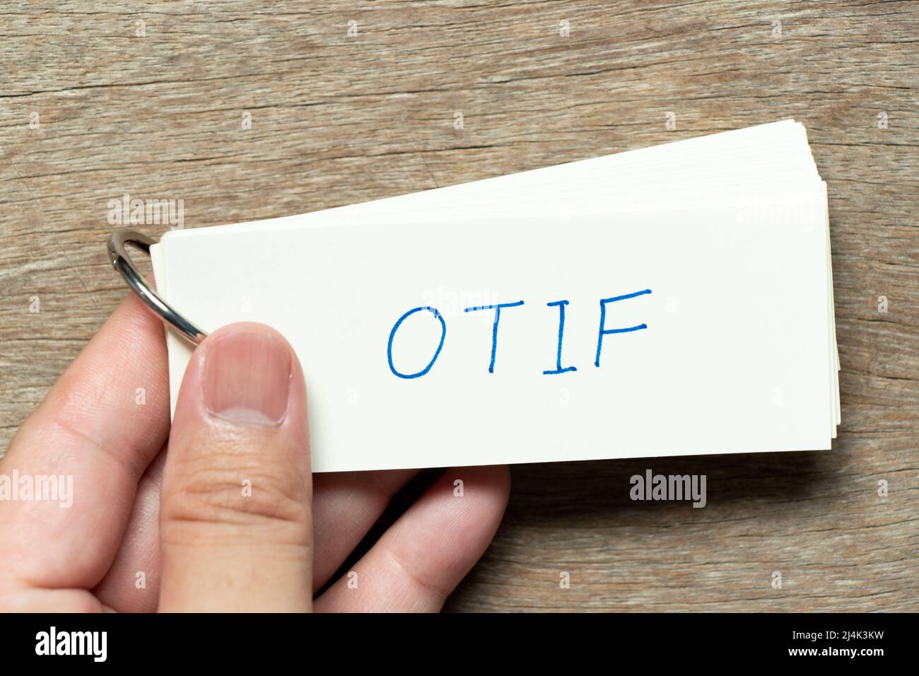 Man hold the flash card with handwriting word OTIF (abbreviation of On ...