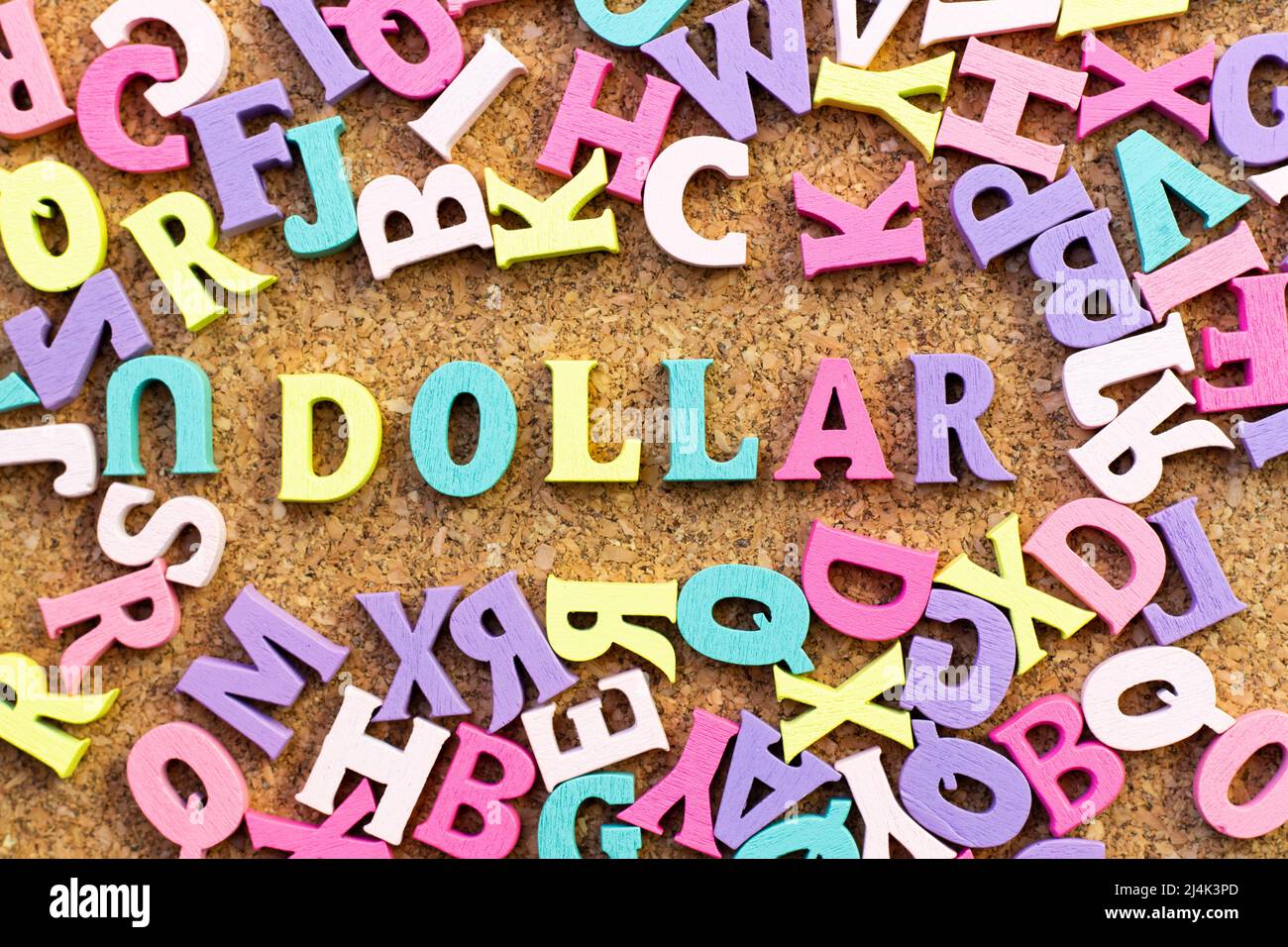 Color alphabet in word dollar with another letter as frame on cork ...