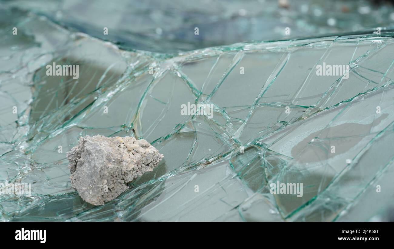 Вroken car windshield with a stone on it. Shattered window surface with ...